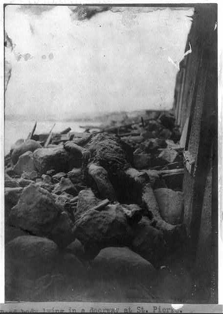Dead body [charred] lying in a doorway [rubble] at St....