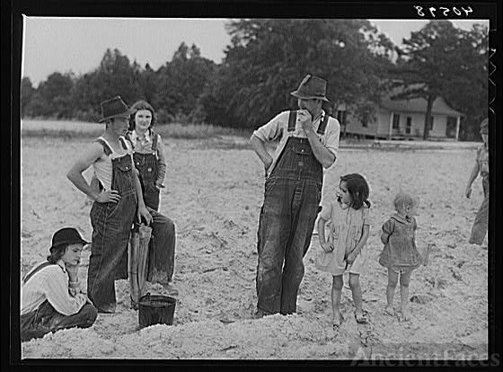 Tenant farmer and part of his family in field ready for...