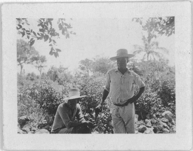 [Two men, one sitting, one standing, possibly from the...