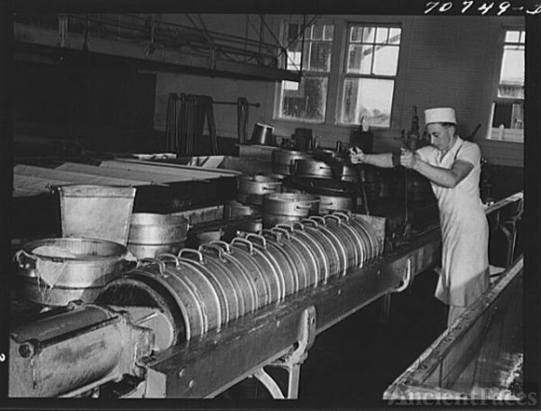 Applying pressure to curd in molds. This process removes...