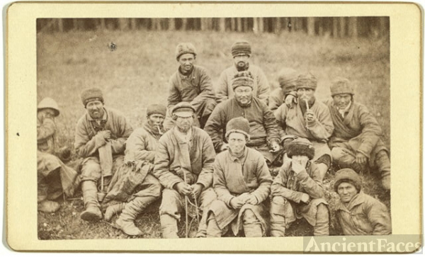 [Group portrait of convicts seated in a field]